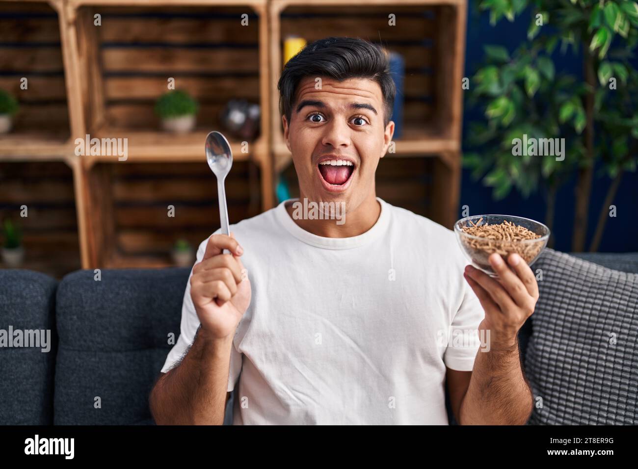 Hispanic man eating healthy whole grain cereals with spoon celebrating ...