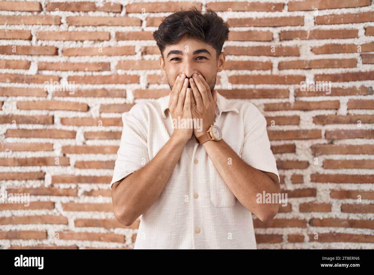 Arab man with beard standing over bricks wall background laughing and ...