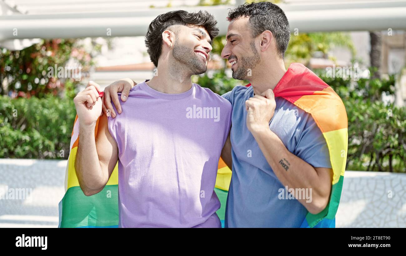 Two men couple hugging each other holding homosexual flag at park Stock ...