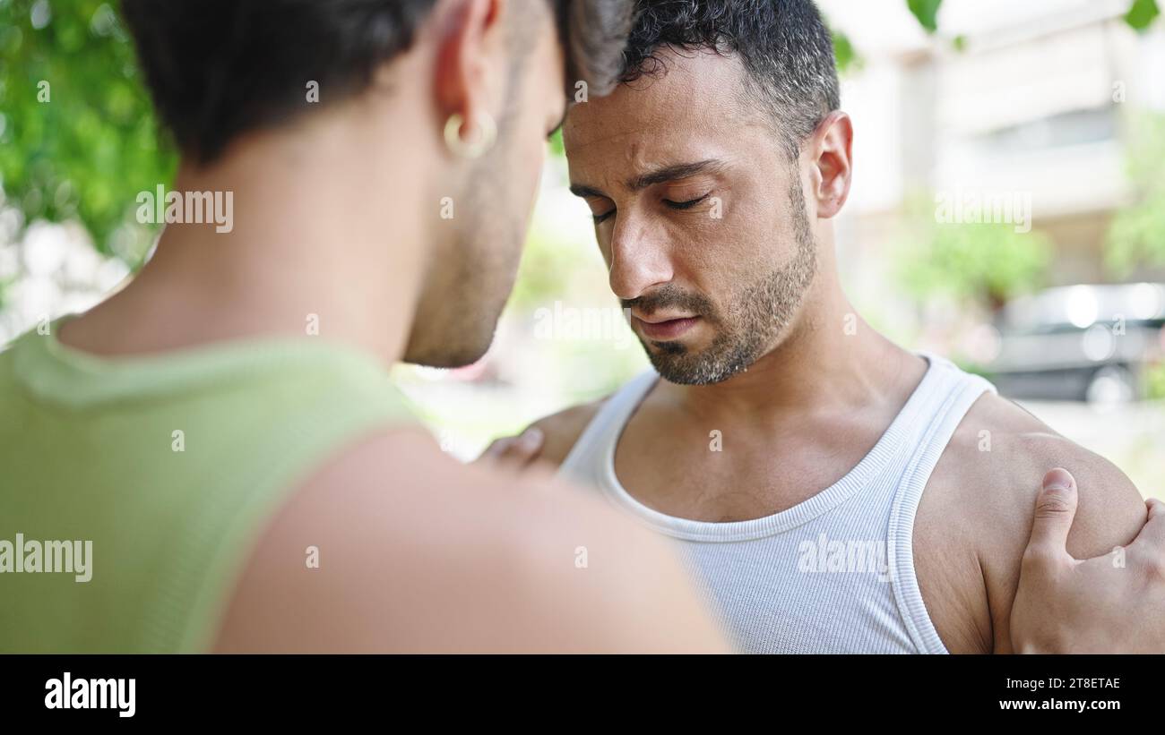 Two men couple supporting at park Stock Photo - Alamy