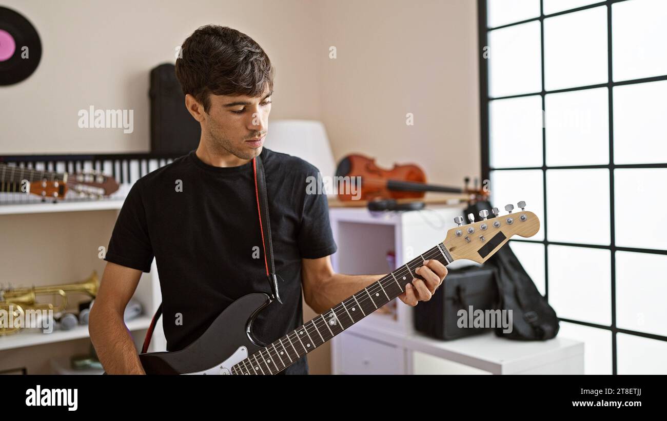 Attractive young hispanic man intensely playing electrical guitar at ...