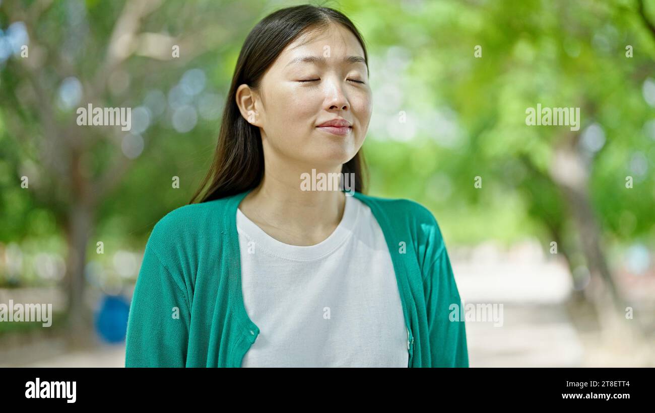 Young chinese woman breathing with closed eyes at park Stock Photo - Alamy