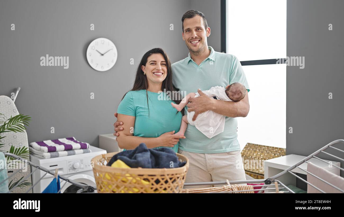 Family of three hanging clothes on clothesline at laundry room Stock ...