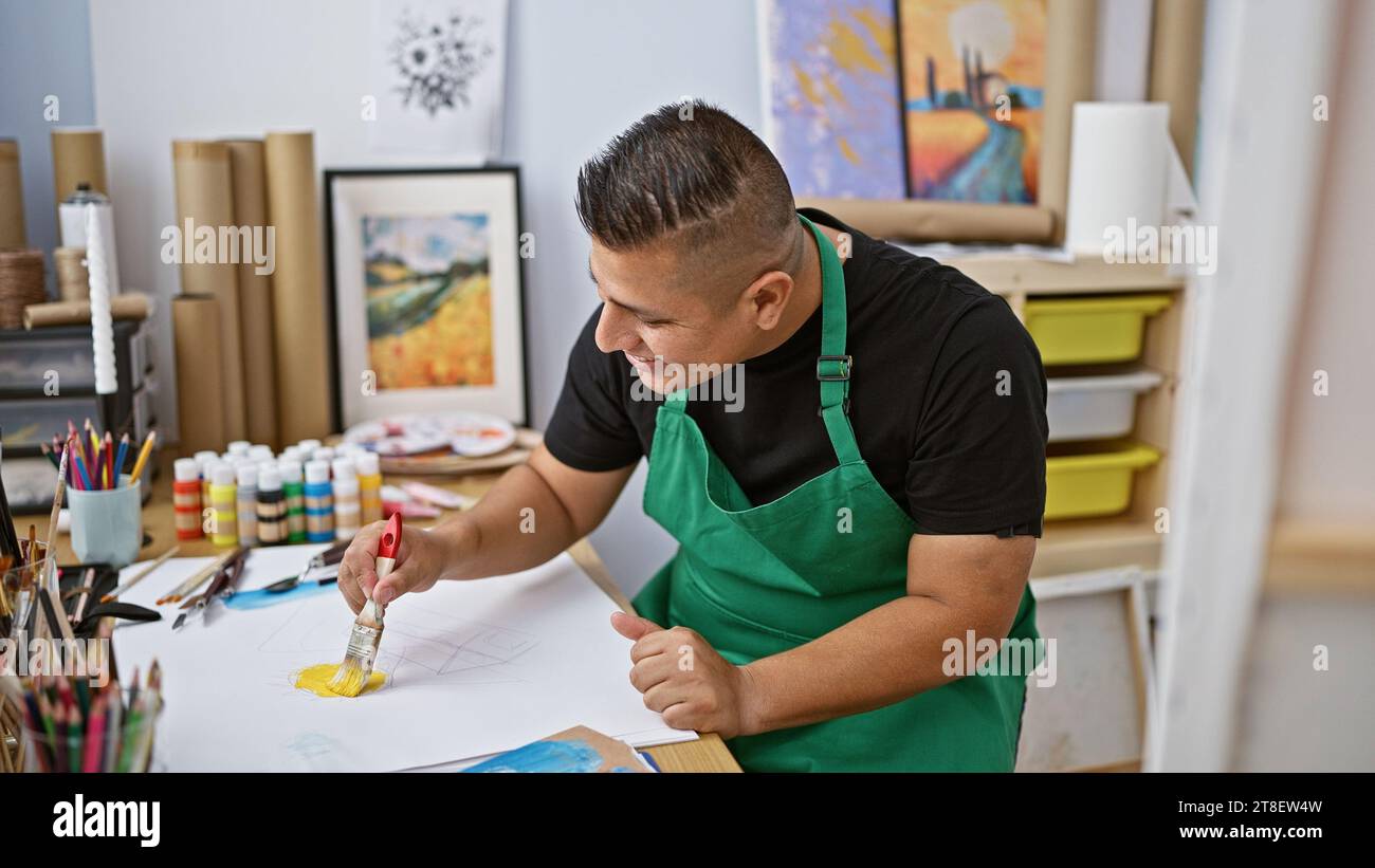 Confident young latin man artist, passionately drawing in his notebook ...