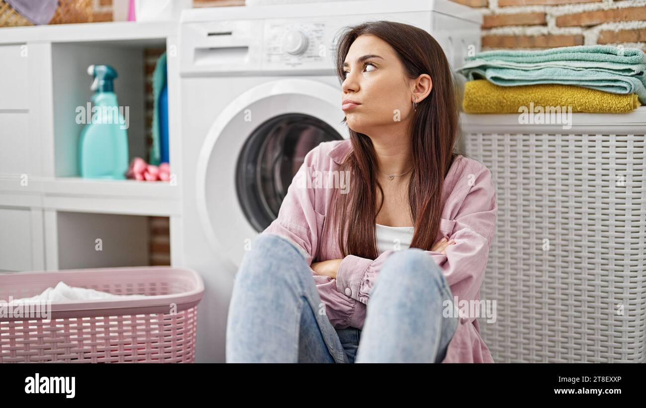 Young beautiful hispanic woman leaning on washing machine with sad ...