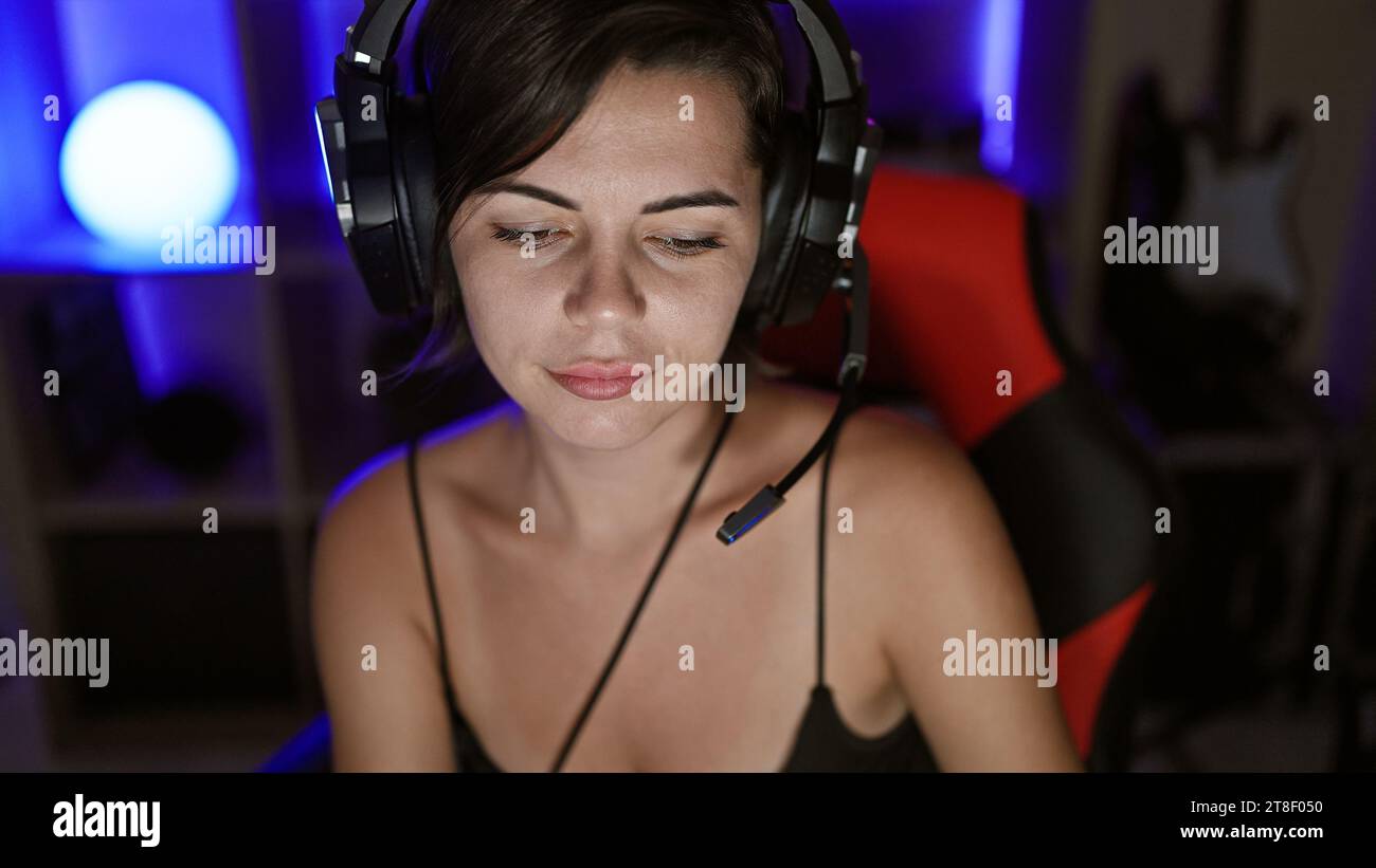 Stunning young hispanic woman streamer, immersed in a gaming stream ...