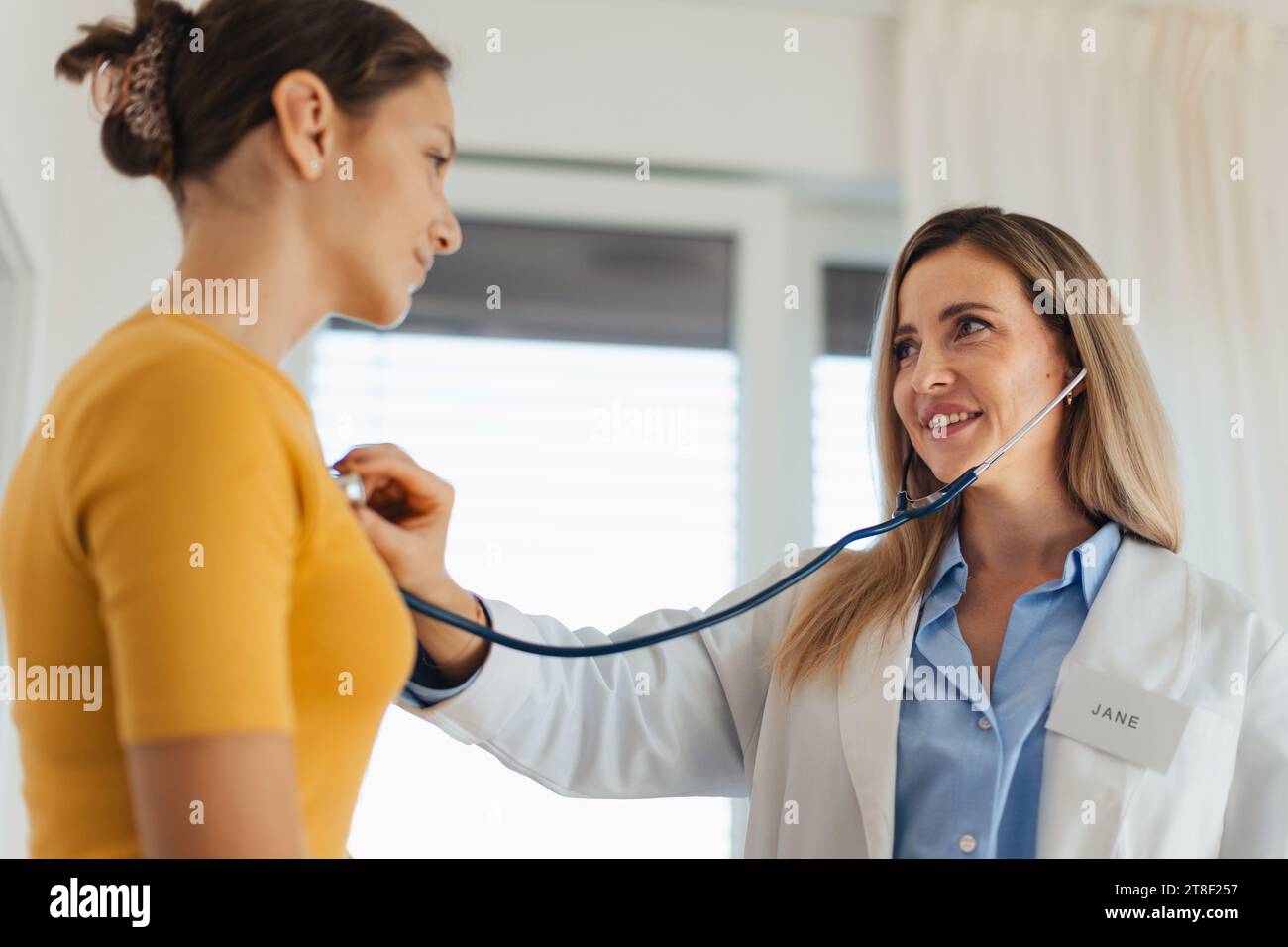 Doctor listening girl's breathing, heartbeats using a stethoscope ...