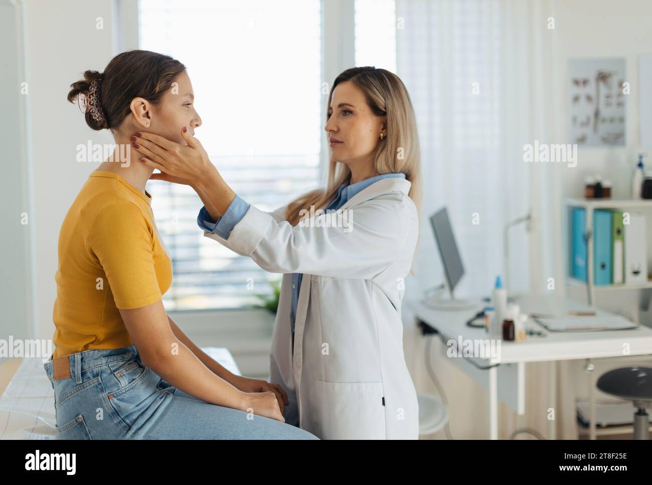 Doctor examining lymp nodes on neck of the teenage girl. Palpation of ...