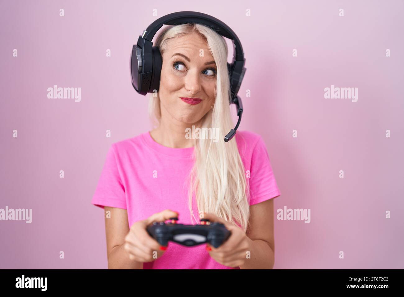 Caucasian woman playing video game holding controller smiling looking ...