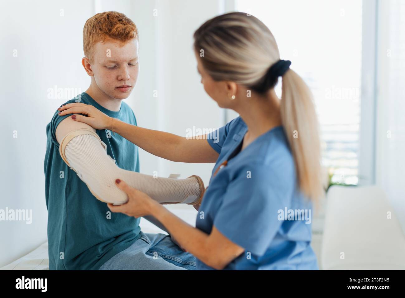 Doctor checking the orthopedic cast, brace on a teenage patient's ...