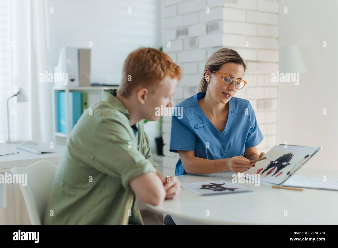 Teenager taking Rorschach test during psychological therapy with ...