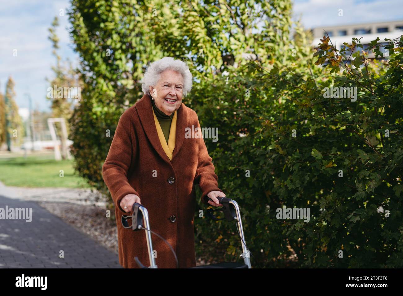Senior woman with a mobility walker walking on city streets during ...
