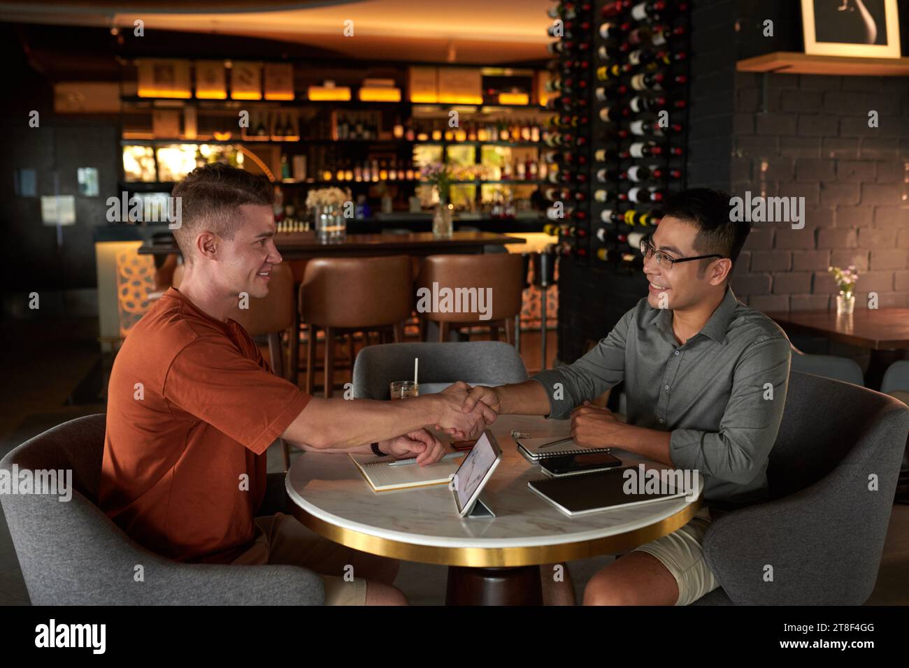 Project founder and software developer shaking hands before discussing ...