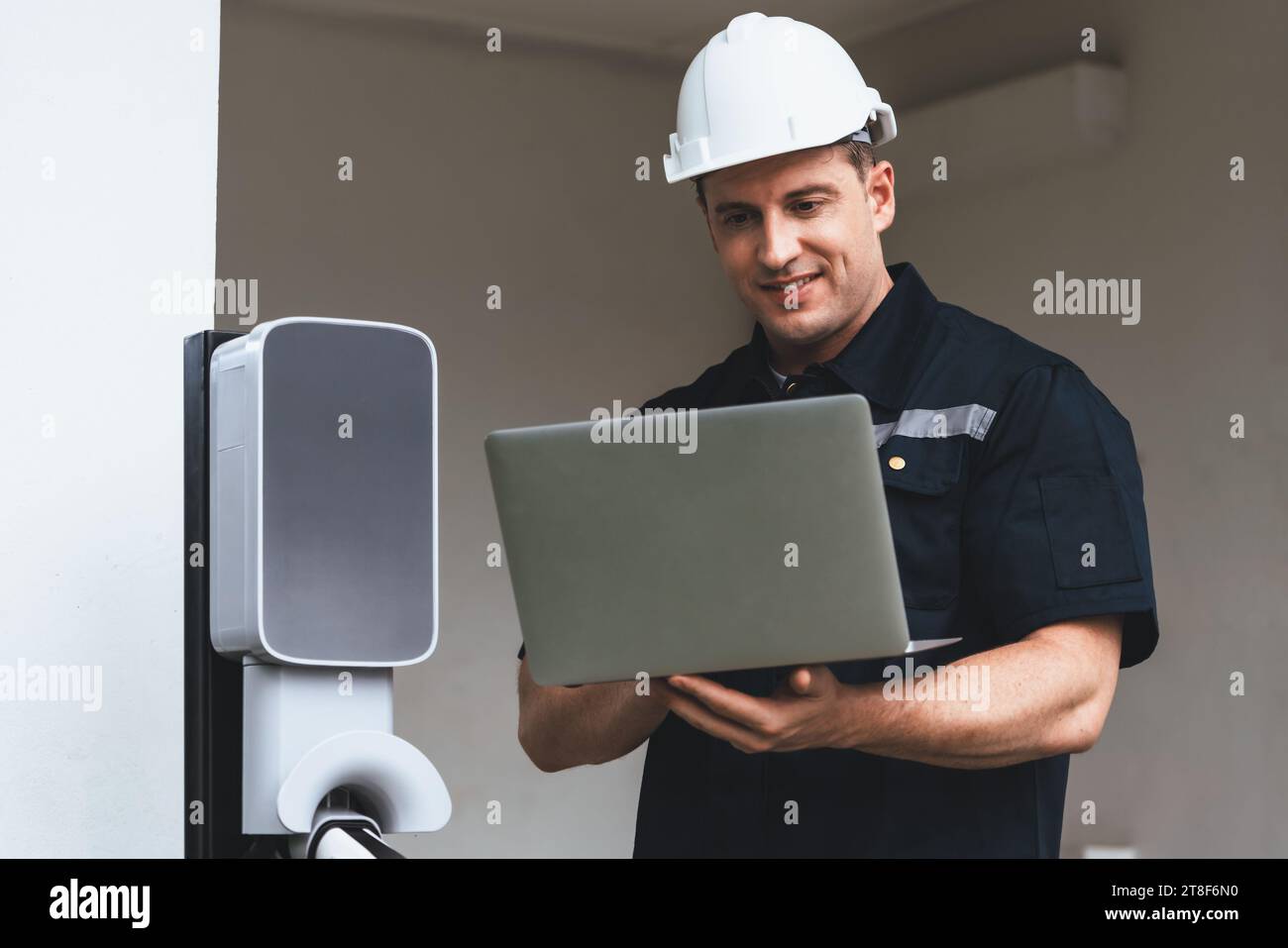 Qualified technician working on home EV charging station installation ...