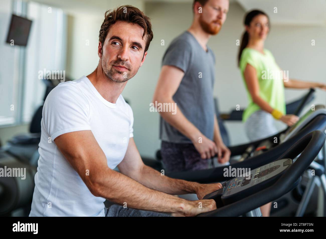 Group of young fit people exercising together during their workout in a ...