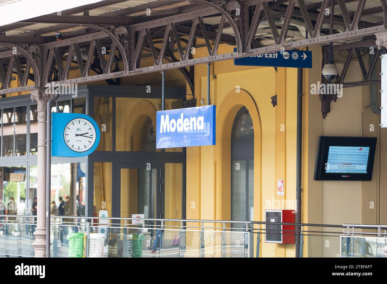 Sign, clock and platform concourse at Modena railway station, Italy ...