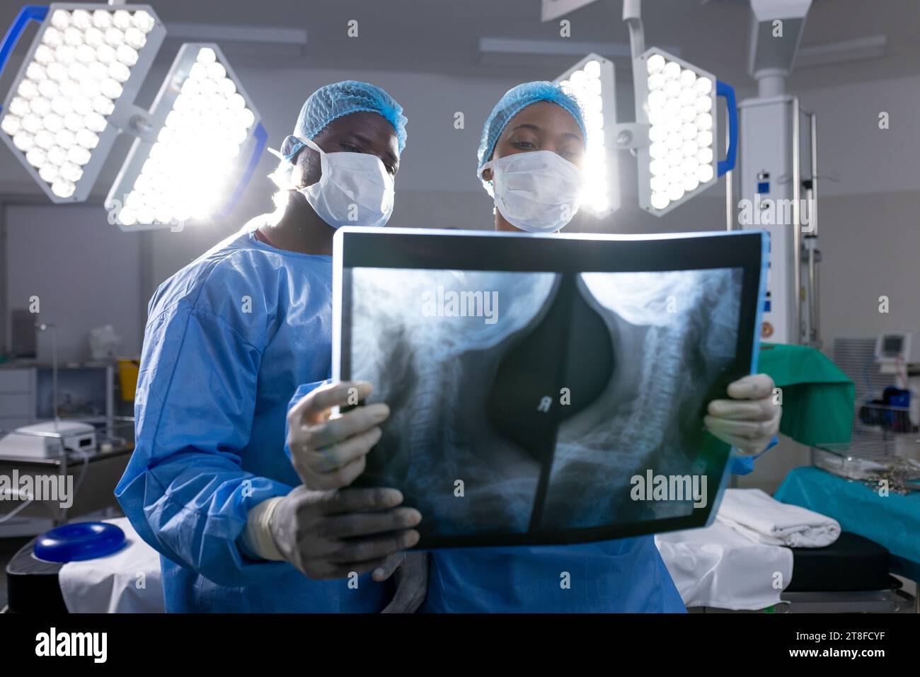 African american male and female doctors with face masks looking at x ...