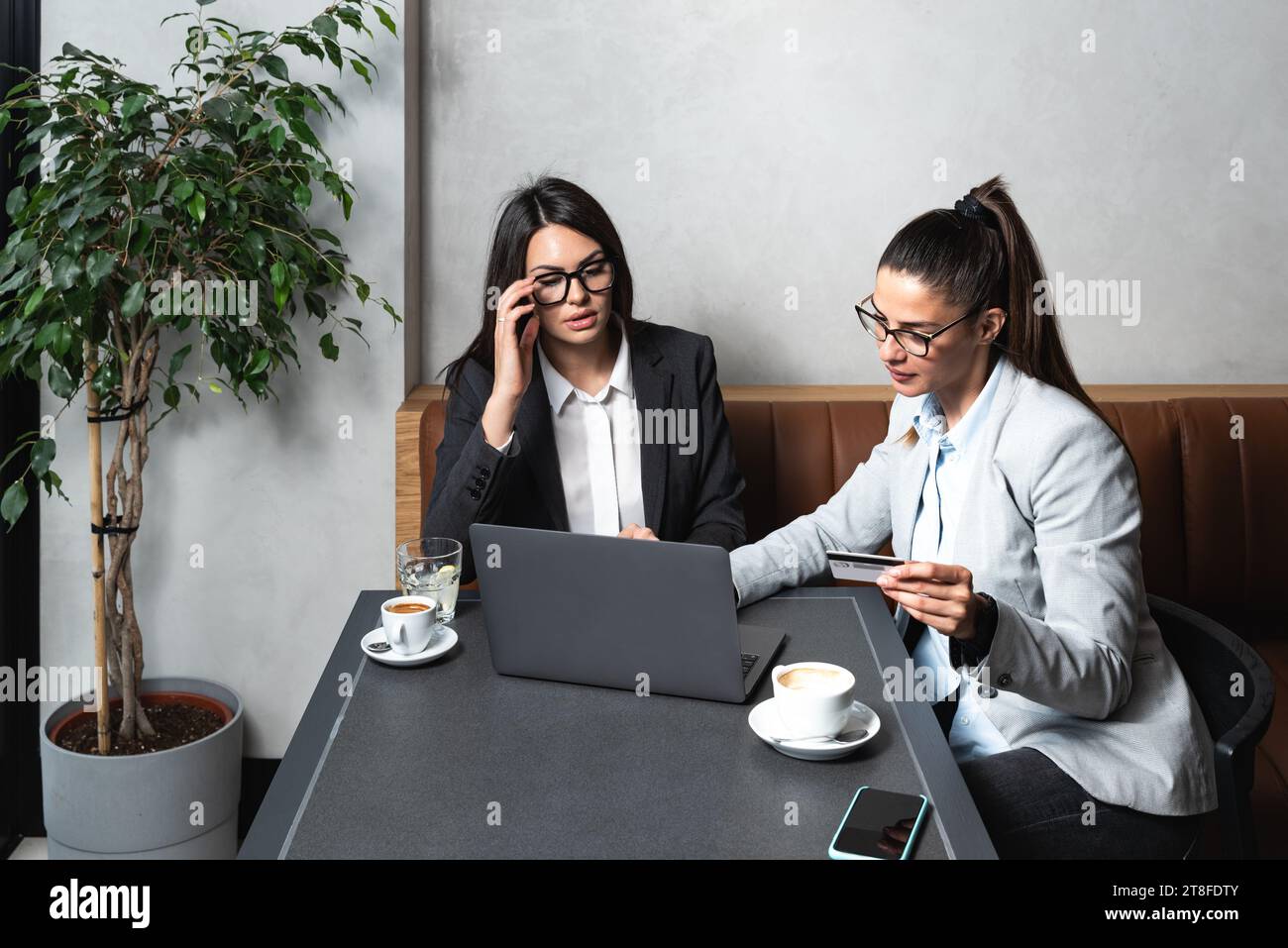 Two young business woman small company owners new business idea sitting ...