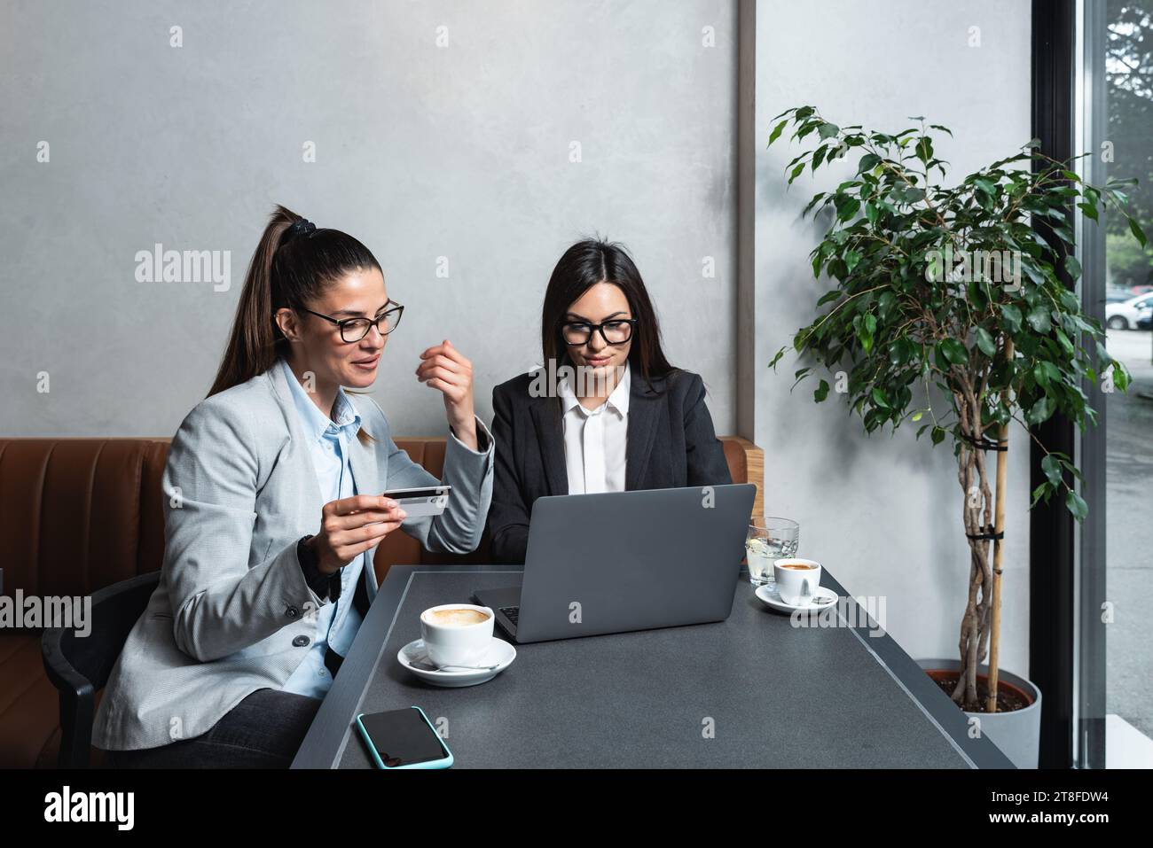 Two young business woman small company owners new business idea sitting ...