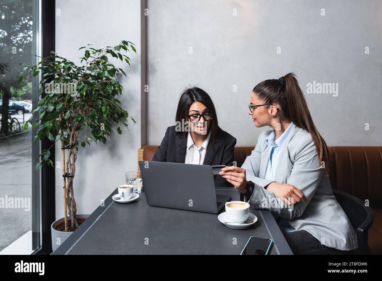 Two young business woman small company owners new business idea sitting ...