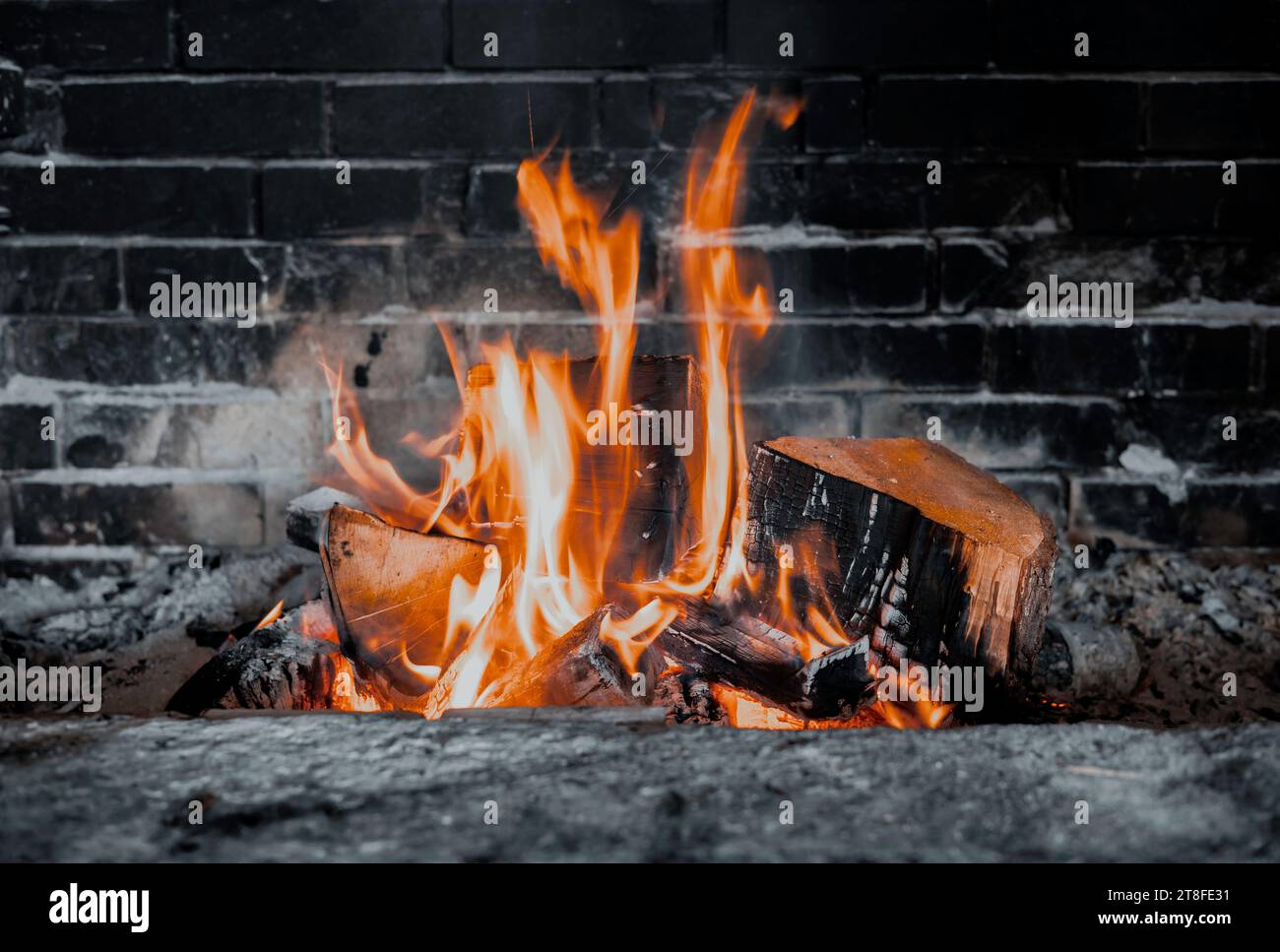 Burning firewood in fire-box of fireplace in country cottage. Rustic ...