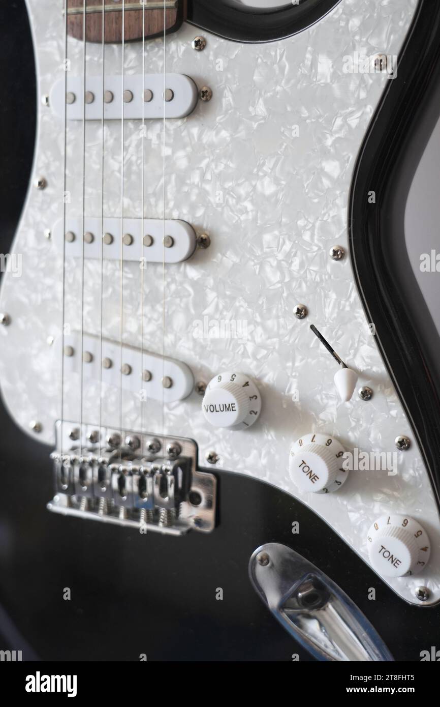 Black and white bodied electric guitar with six strings on the black ...
