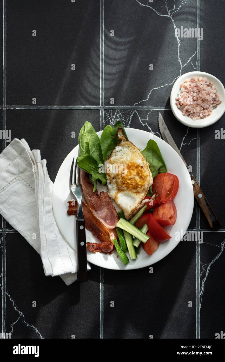 Top view of well balanced breakfast setup with a fried egg, bacon ...