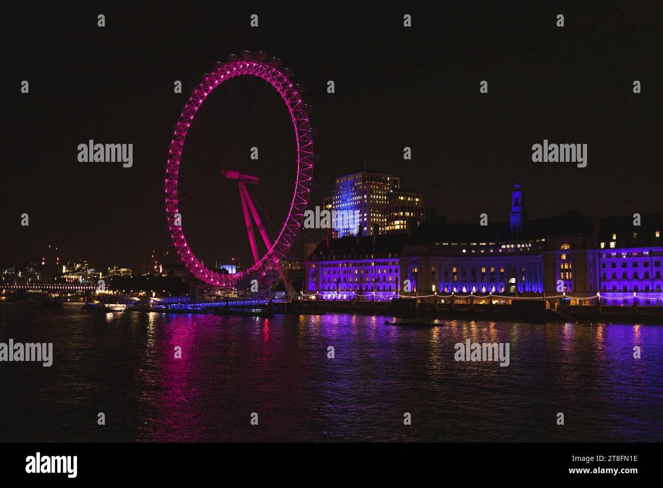 The iconic London Eye illuminated in vibrant pink, dominating the night ...