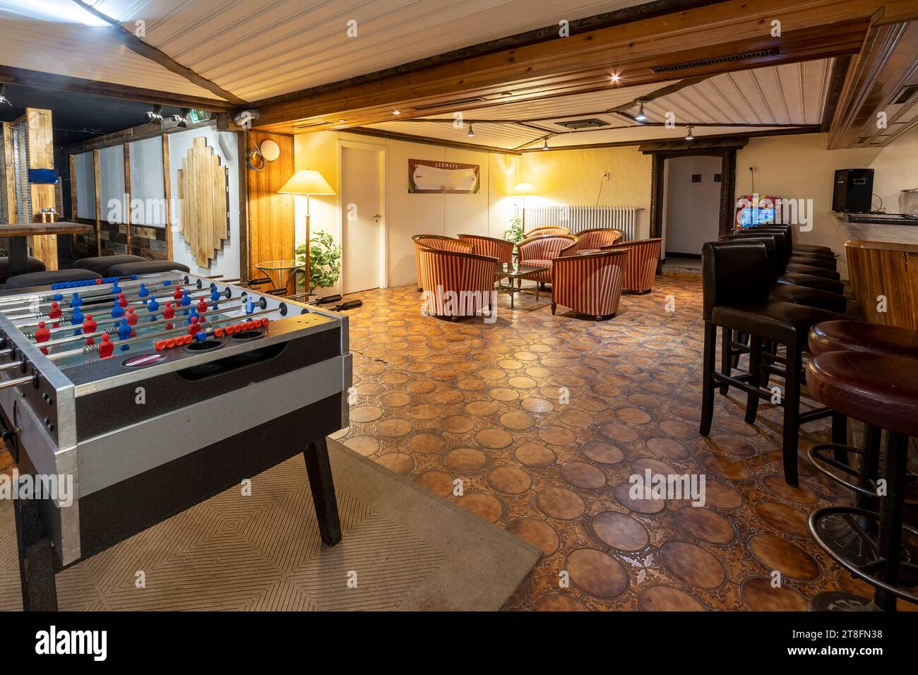 A home's basement area turned into a warm bar room with a foosball ...