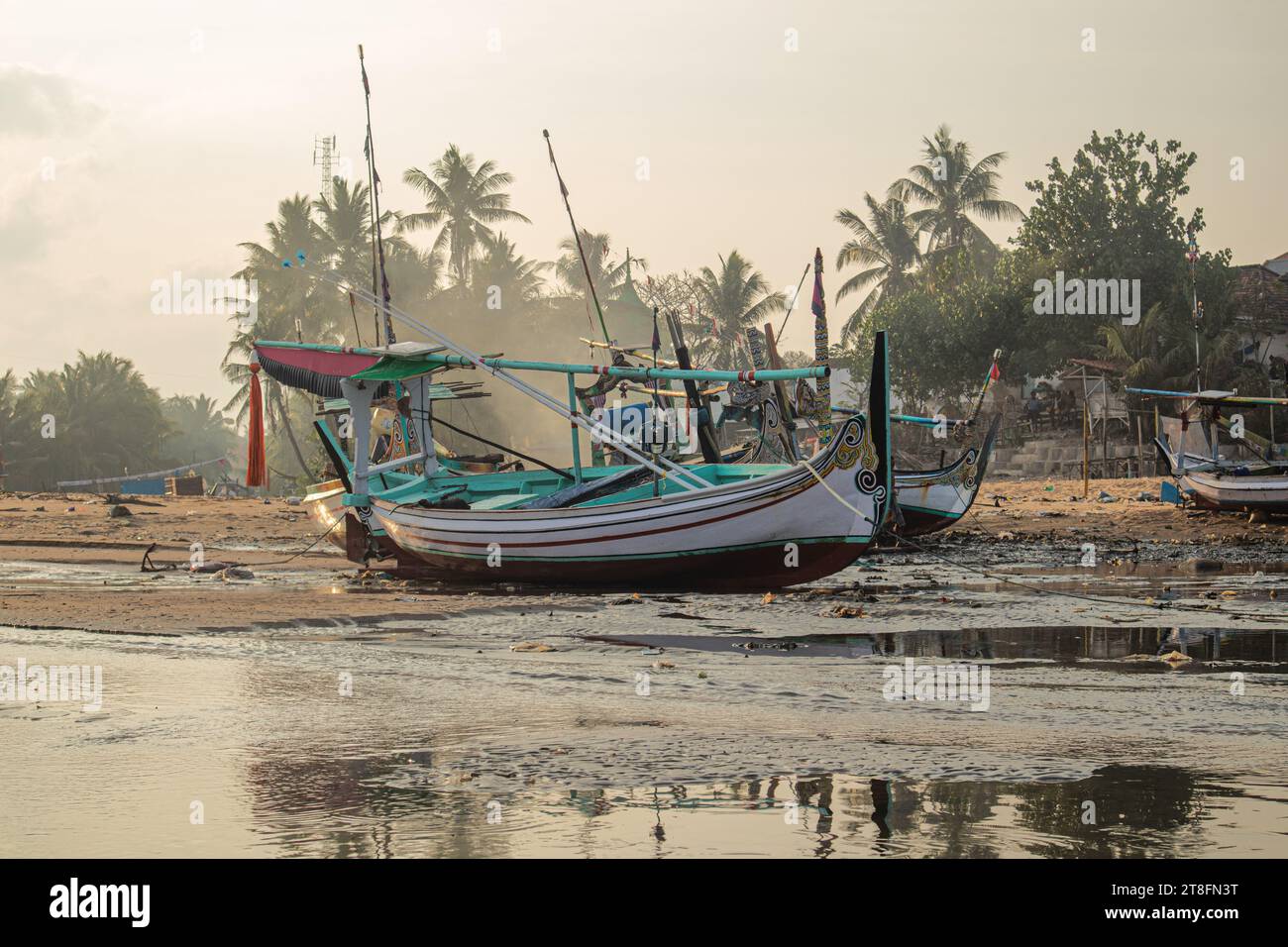 Fishing boats are stranded on the beach because sea water recedes in ...
