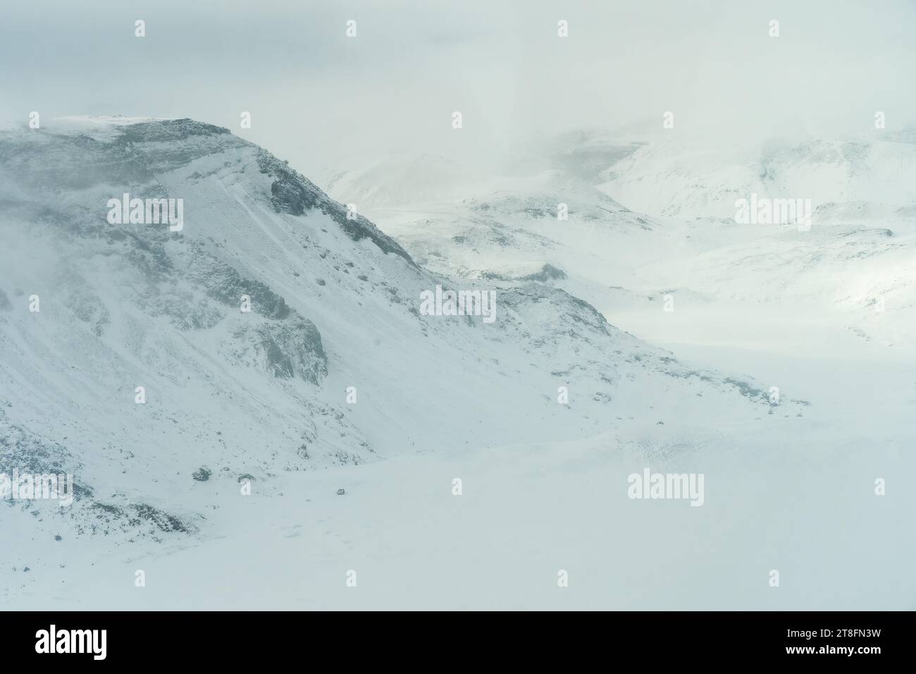 Aerial view of snow-blanketed mountain slope, with the soft haze ...