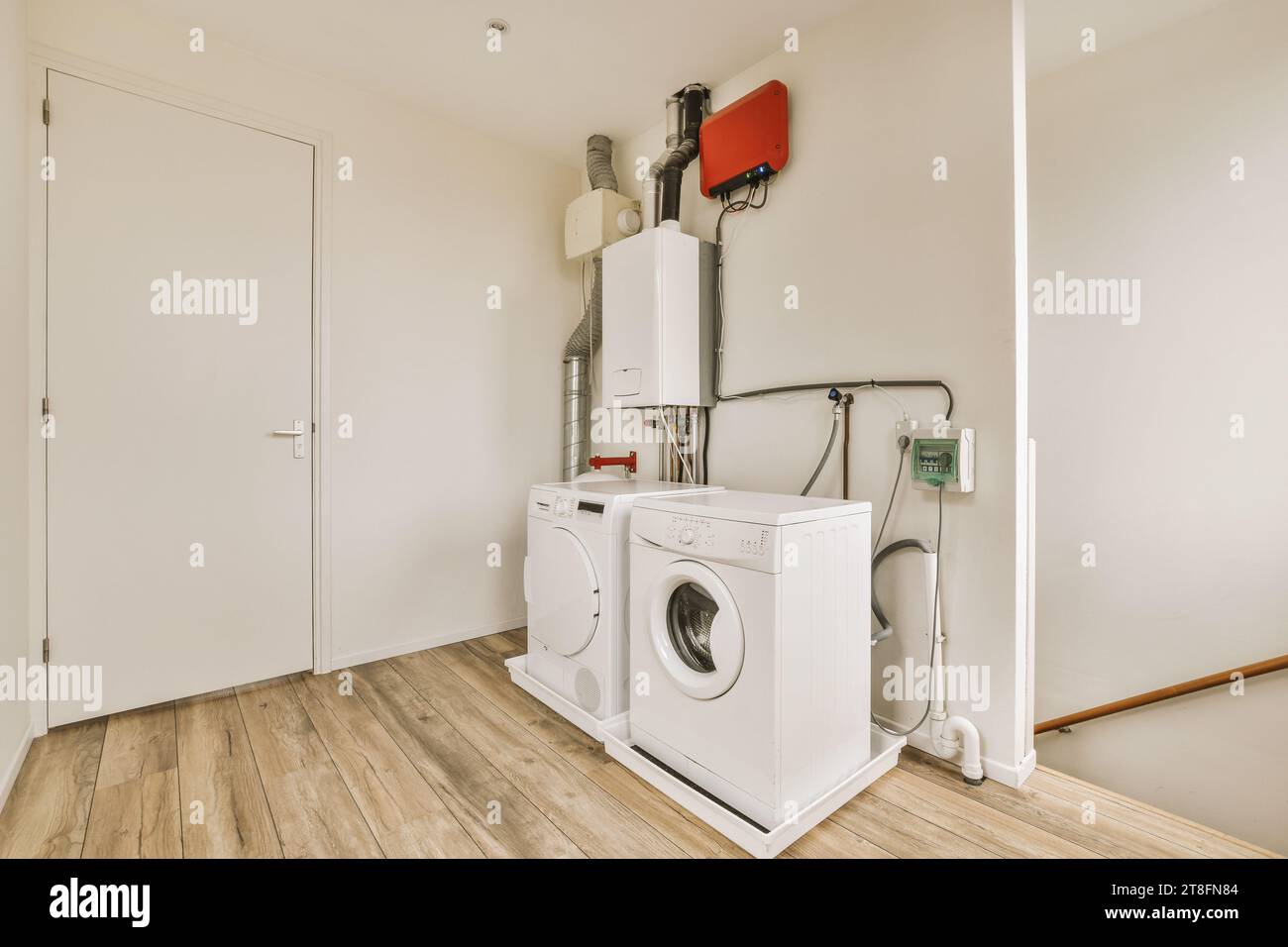 Washer and dryer machines on floor in laundry room of modern home with ...