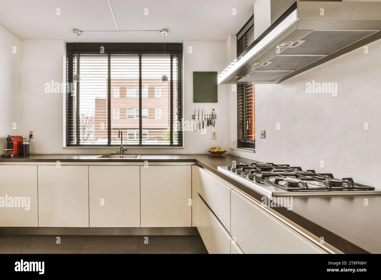 Rangehood over stove on countertop in modern kitchen with window and ...