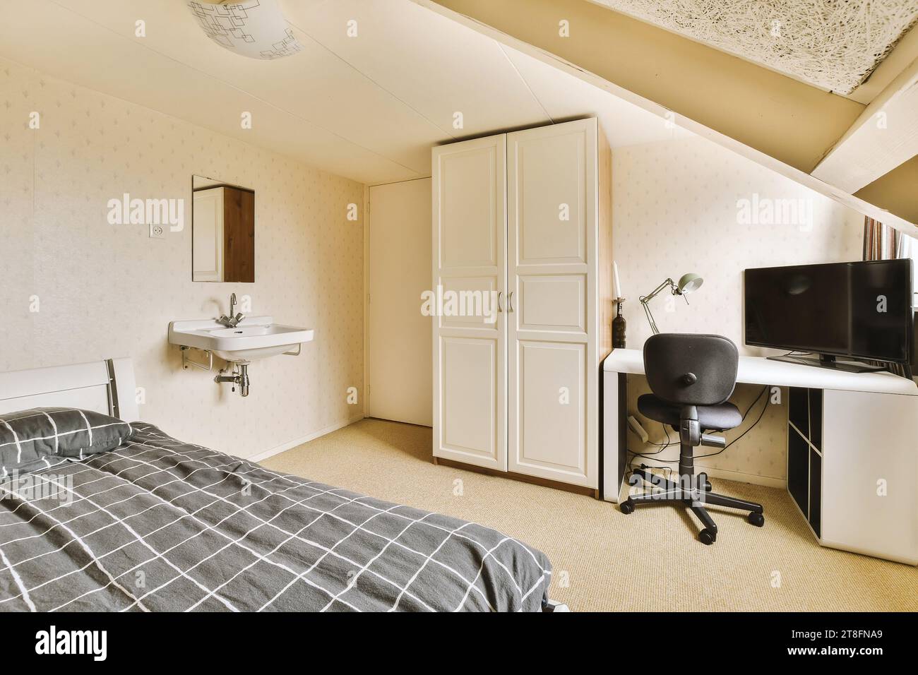 Small bed with wardrobe and computer on desk in bedroom with white ...