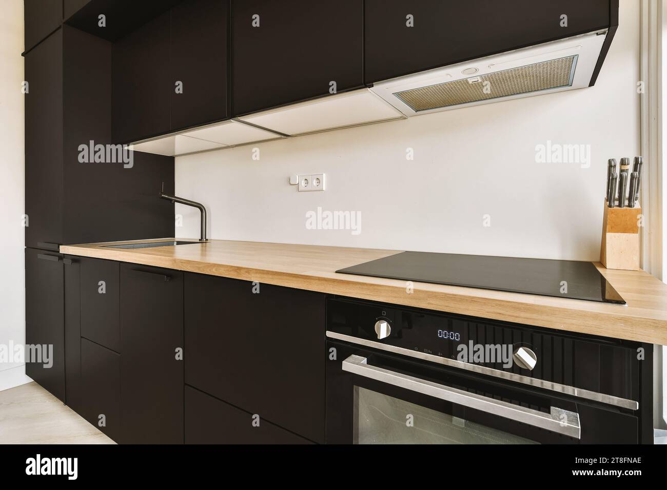 Interior of modern kitchen with induction and rangehood and black ...