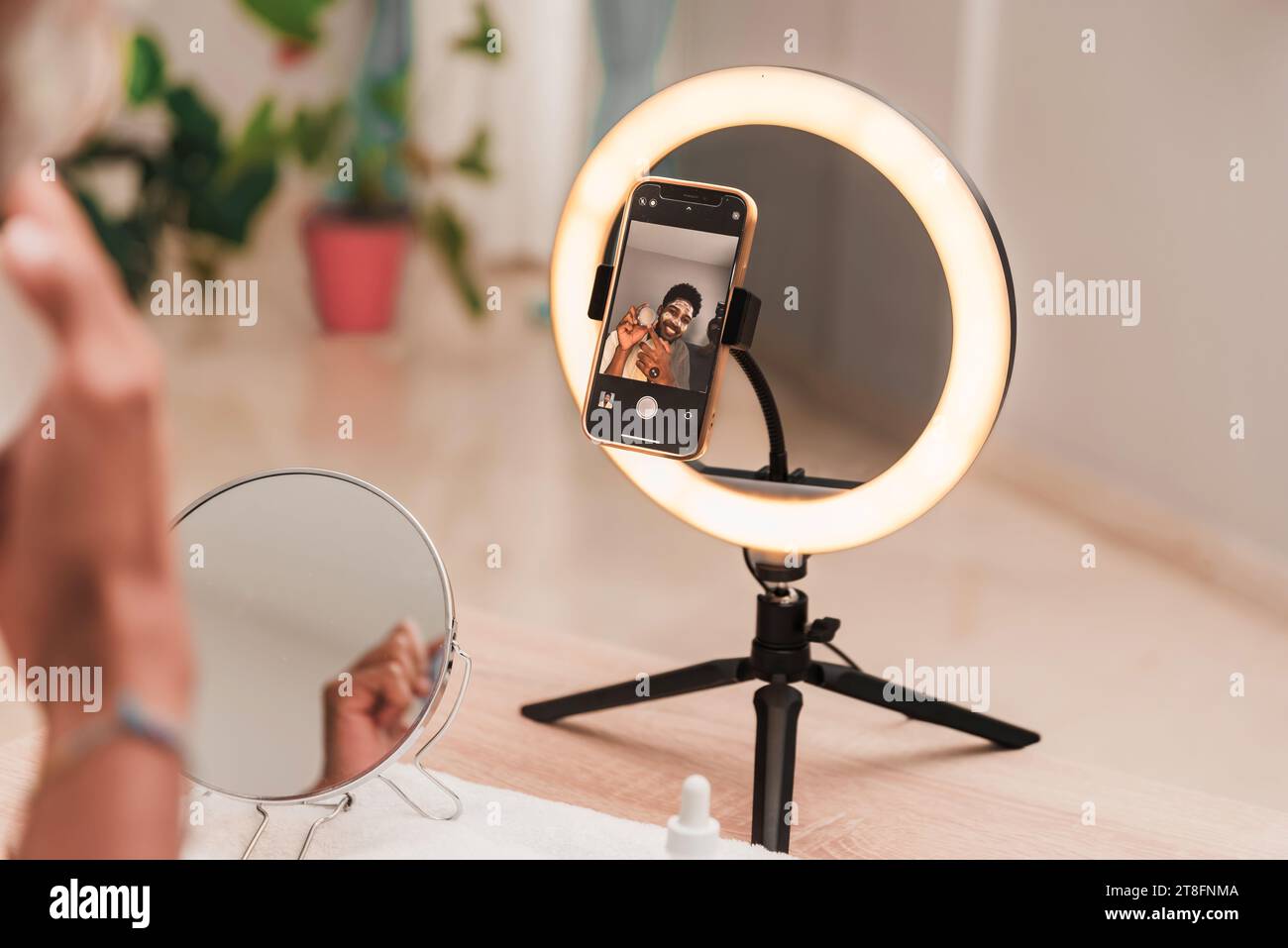 An individual captures themselves on a smartphone mounted on a ring ...