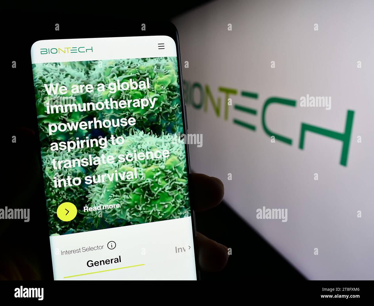 Person holding mobile phone with web page of German biotechnology ...