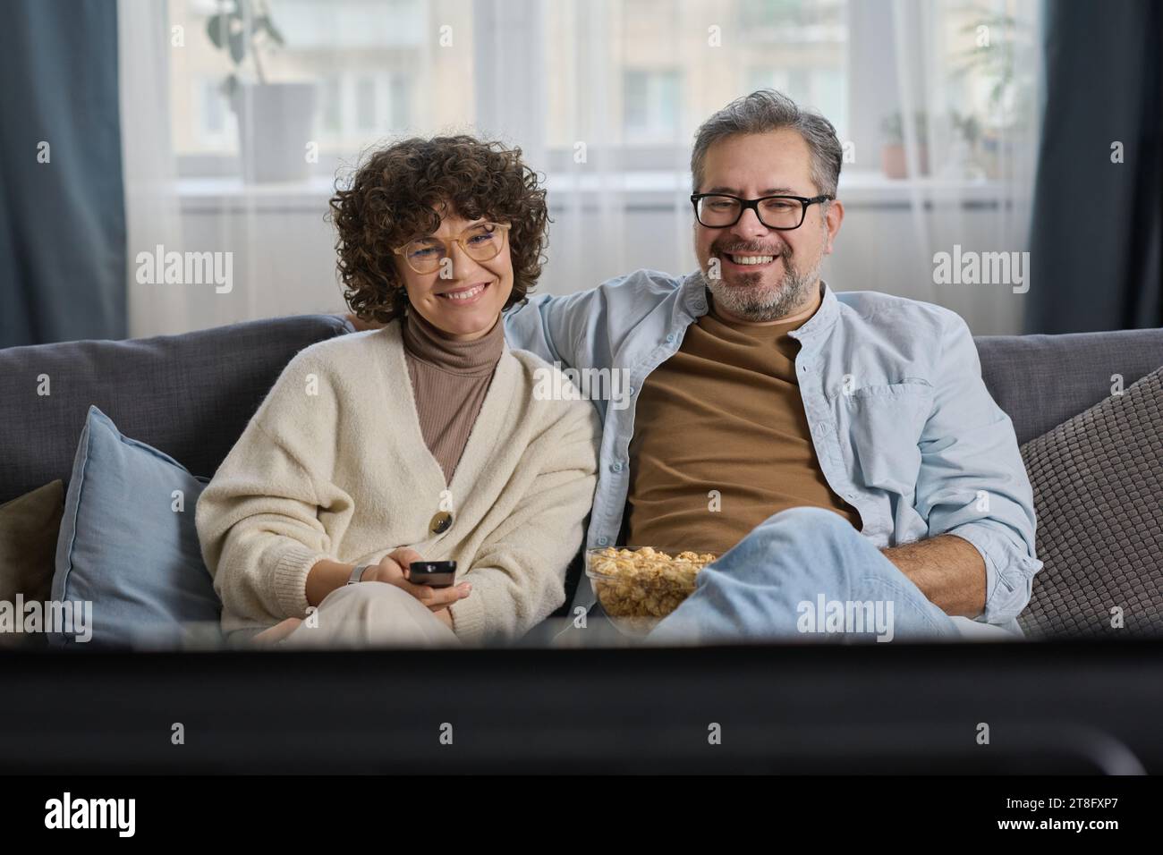 Happy family watching movie together hi-res stock photography and ...