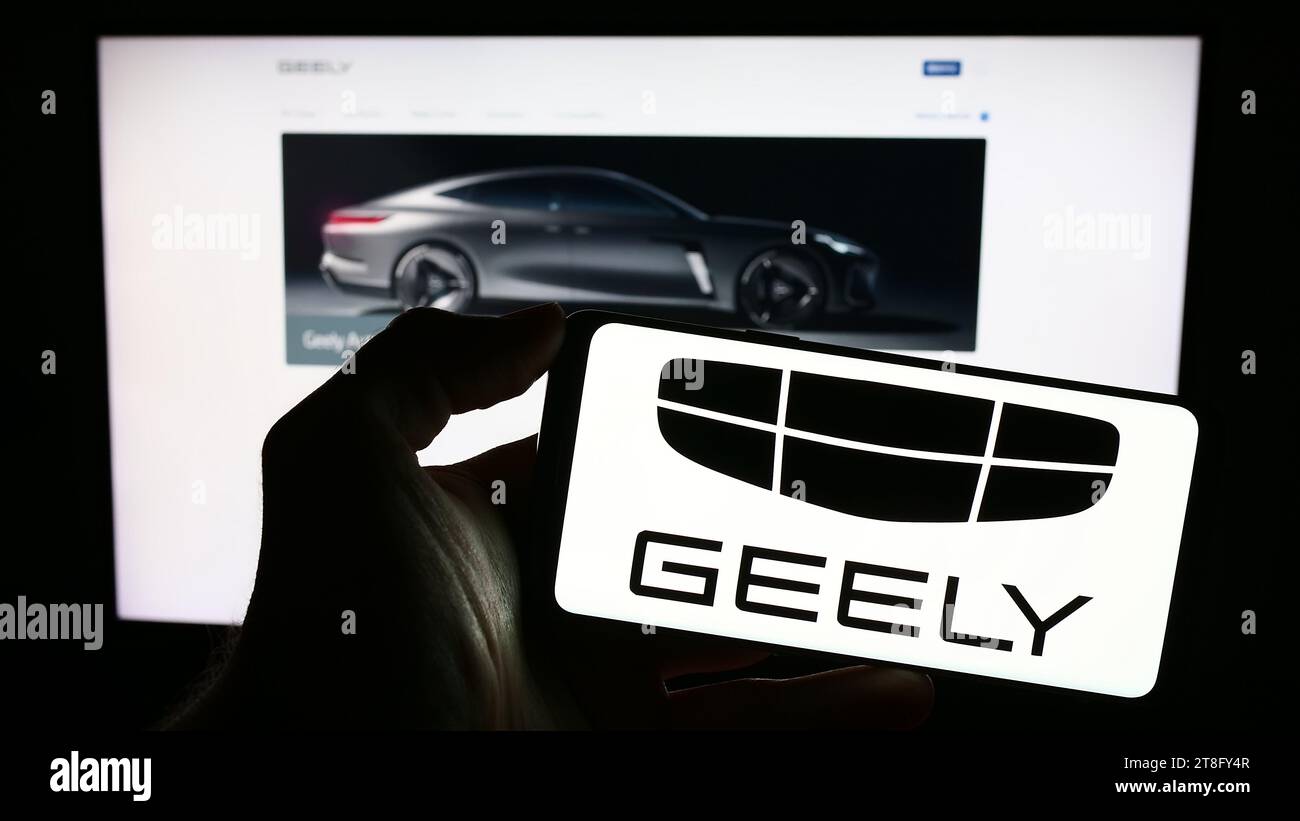 Person holding mobile phone with logo of Chinese car manufacturer ...