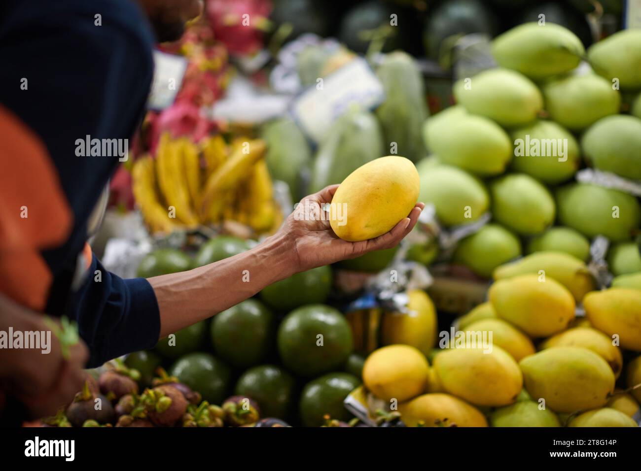 Customer buying fresh mangoes at local market Stock Photo - Alamy