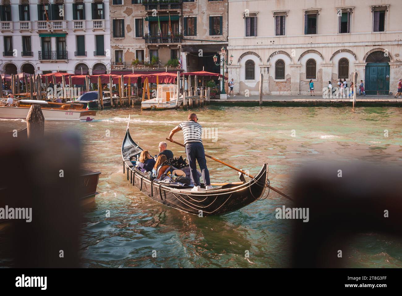 Traditional black gondola floating peacefully in the bright and clear ...
