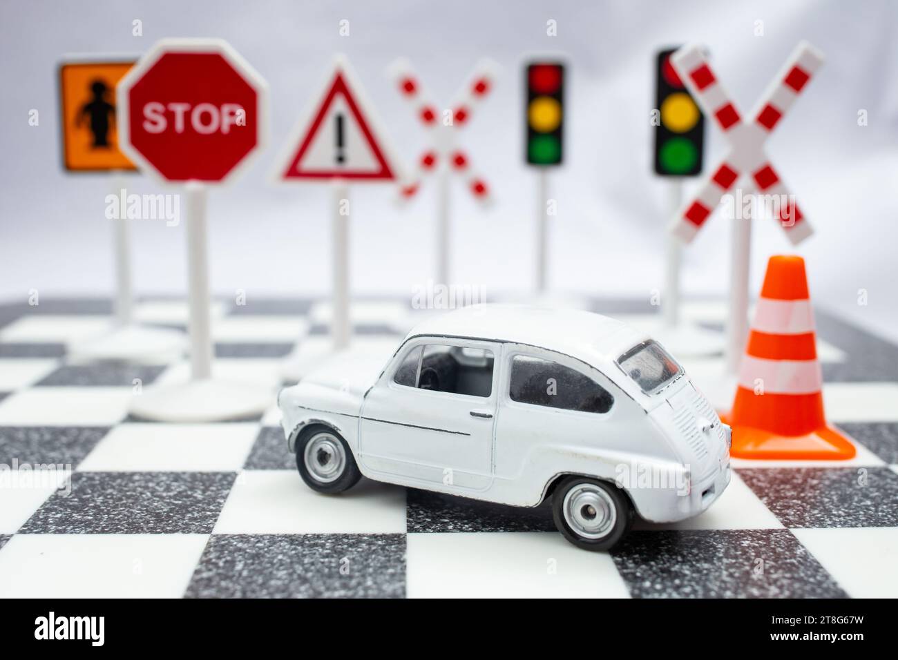 white little model car with traffic signs on a chess board, driving ...