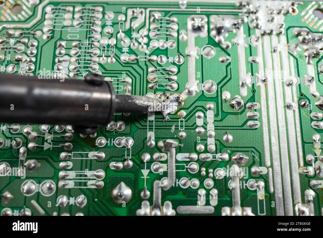 Close up of a soldering iron working on a motherboard circuit, soft ...