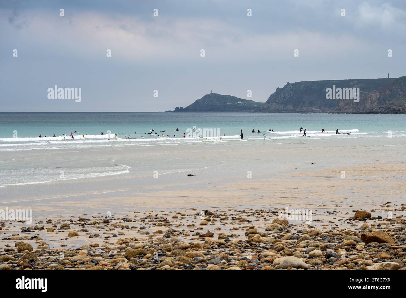 People surf on the beach at Sennen near Land's End in Cornwall, with ...