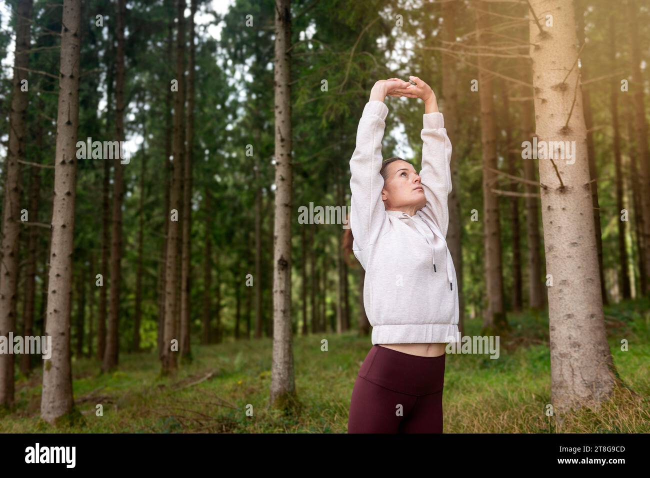 fit sporty woman doing stretching exercise in the forest, warm up ...