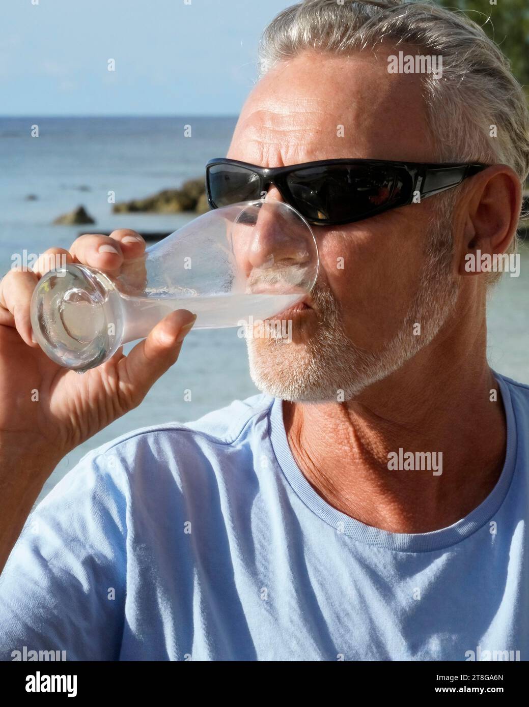A handsome elder French man with grey hair and a grey beard wearing ...