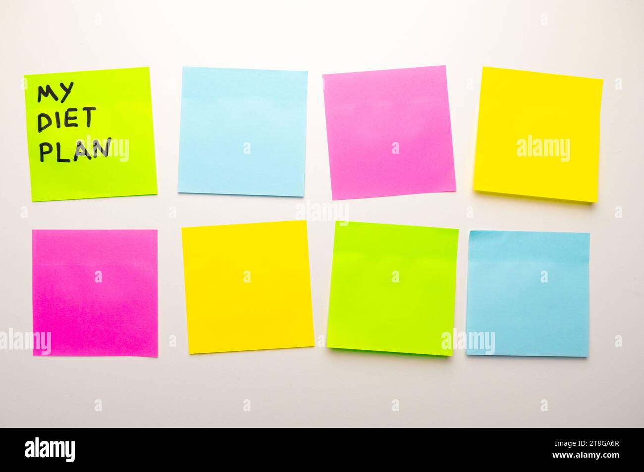 Colorful sticky sheets, and "diet plan" text on white surface. Drawing ...