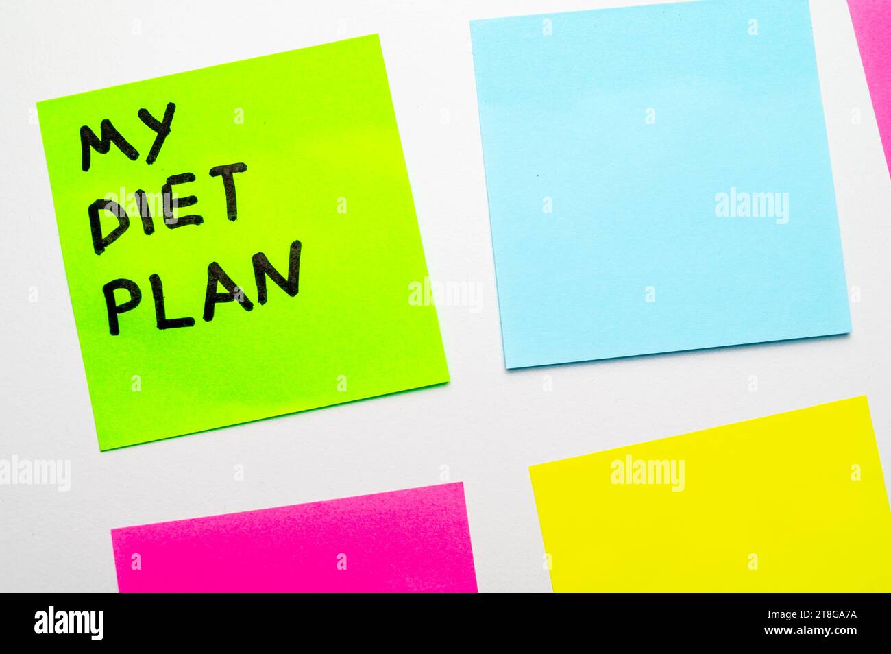 Colorful sticky sheets, and "diet plan" text on white surface. Drawing ...