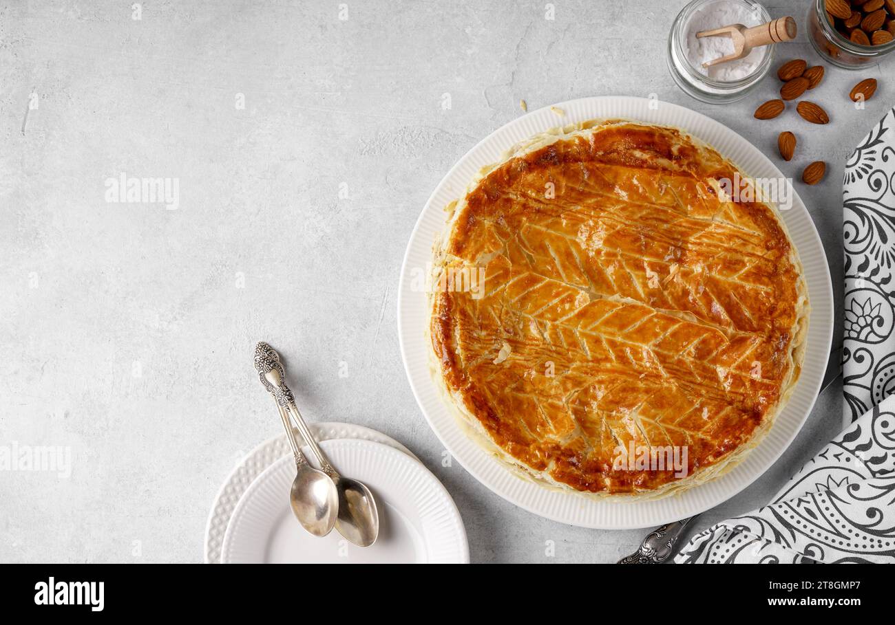 A traditional French galette des rois with almonds plate and cutlery ...