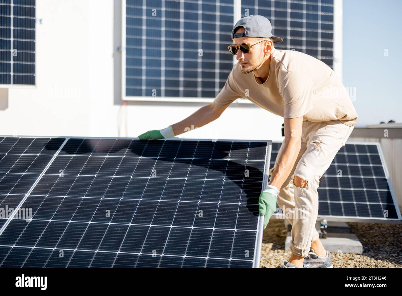 Man installing solar panels on the roof of his house Stock Photo - Alamy